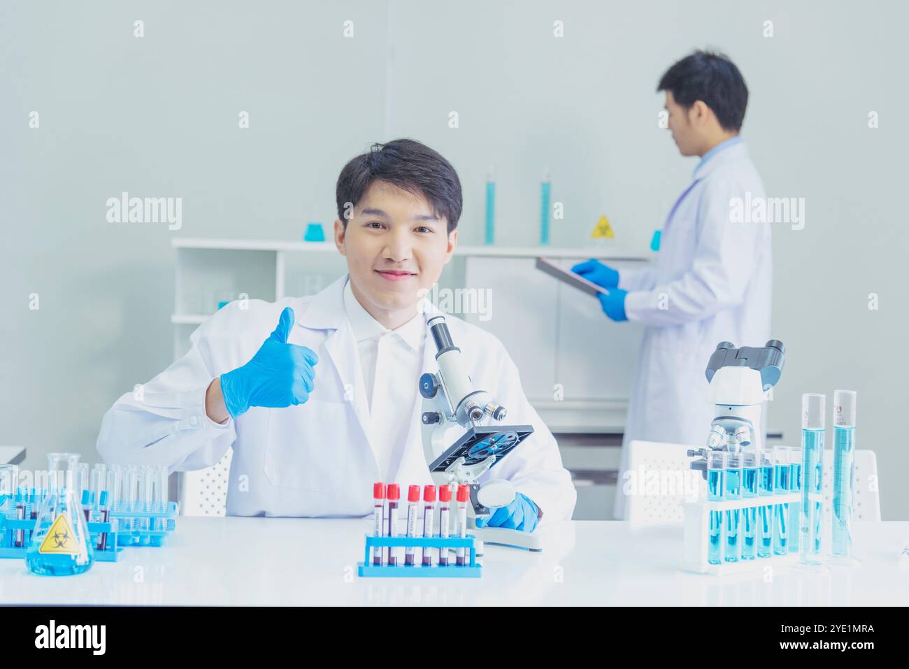 Two asian scientist team reserch chemistry science tube experiment ...