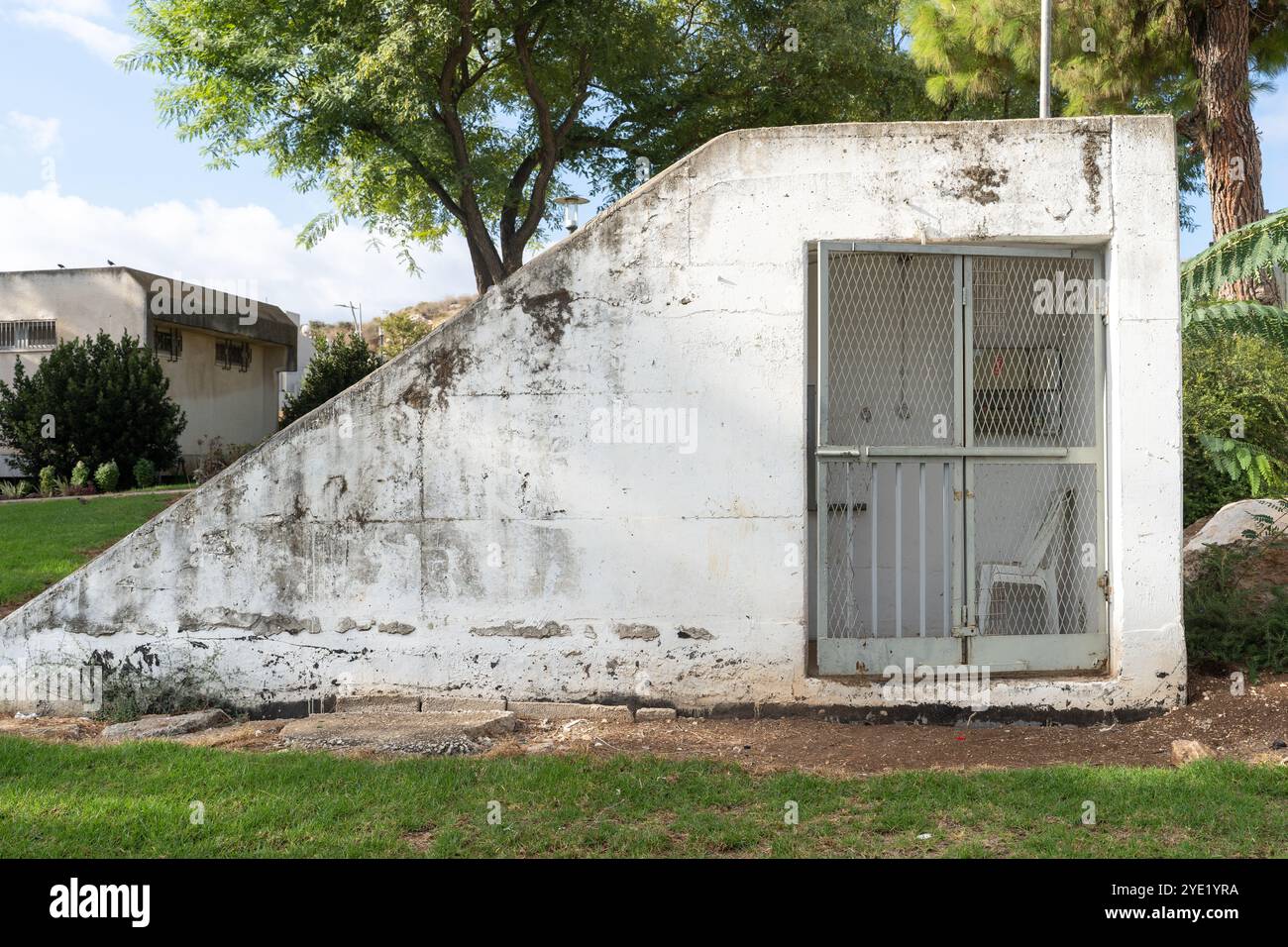 An outdoor bomb shelter in Israel, surrounded by green grass and trees ...