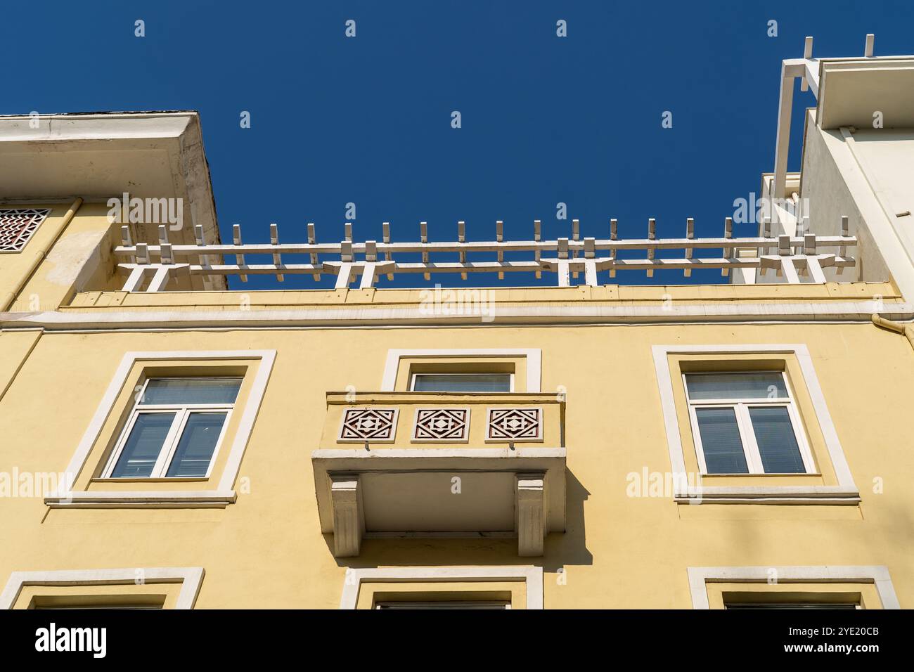 Low-Angle View of Yellow Building Exterior: Balcony and Window Frames ...