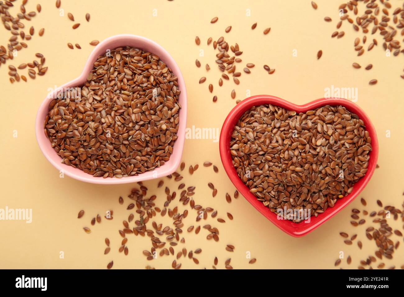 Healthy food. Flax seeds in pink and red heart shaped bowls on beige background. Top view Stock ...