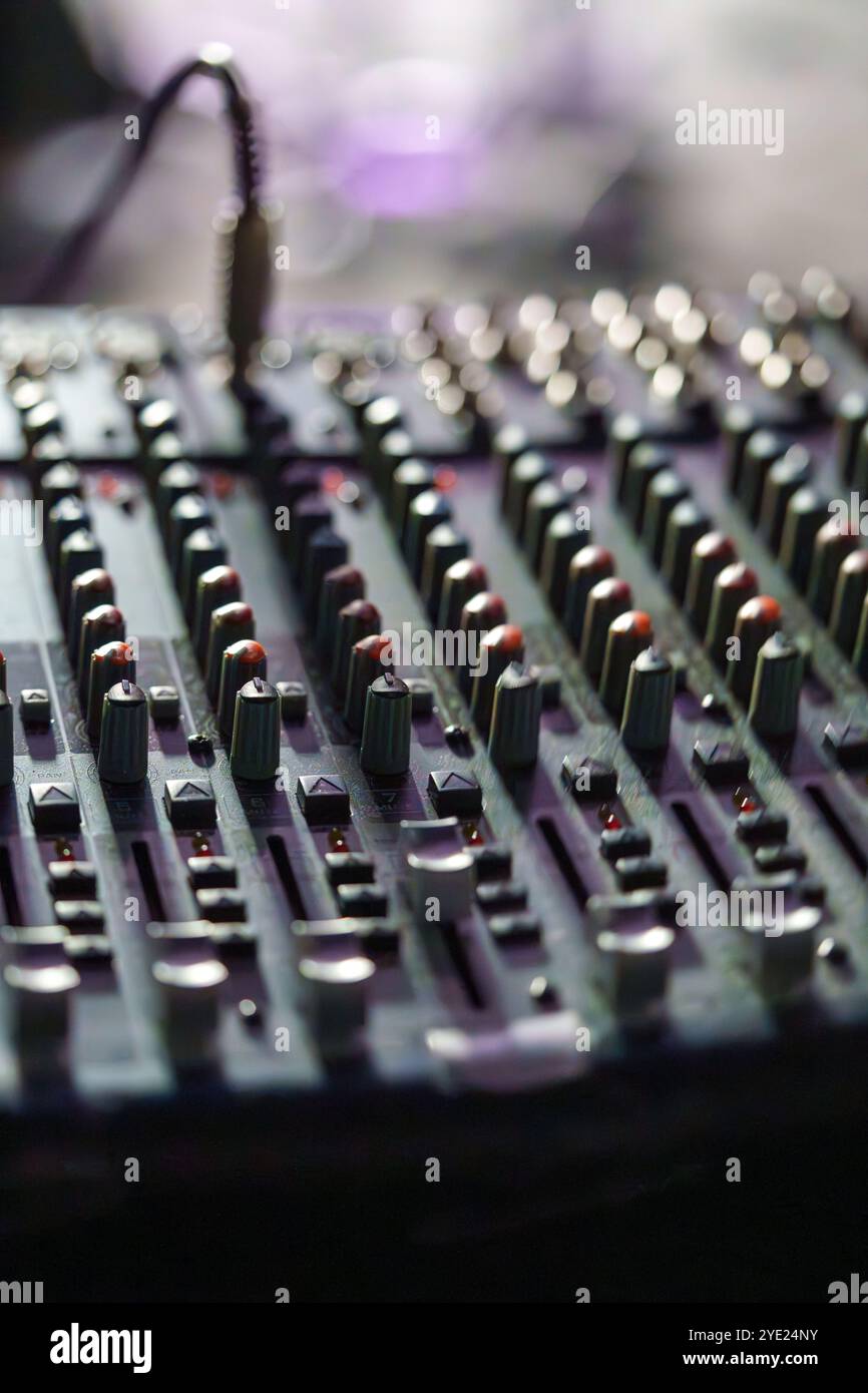 Close-up of an Audio Mixing Console with Faders and Knobs in Low Light ...