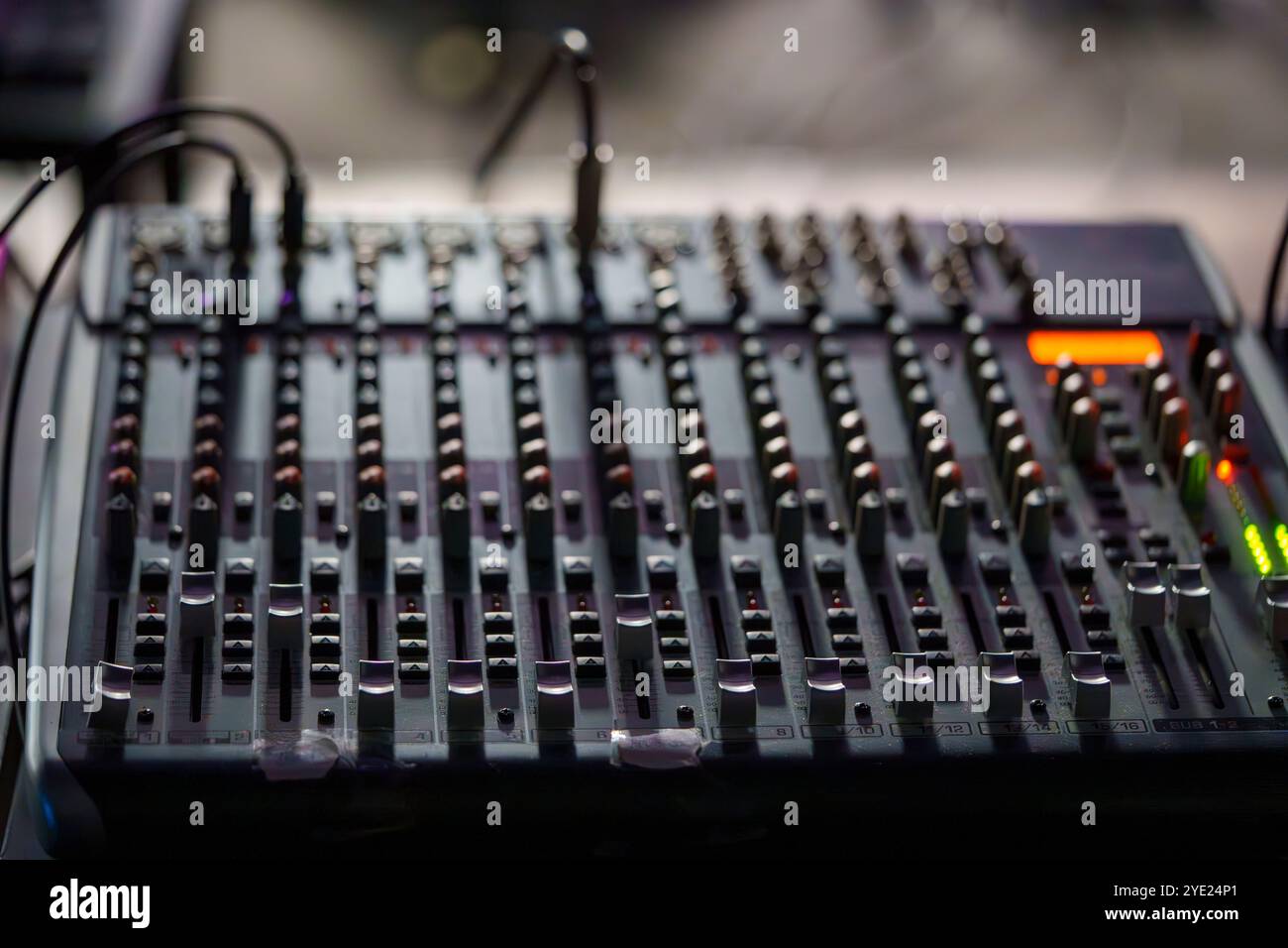Close-up of an Audio Mixing Console with Faders and Knobs in Low Light ...