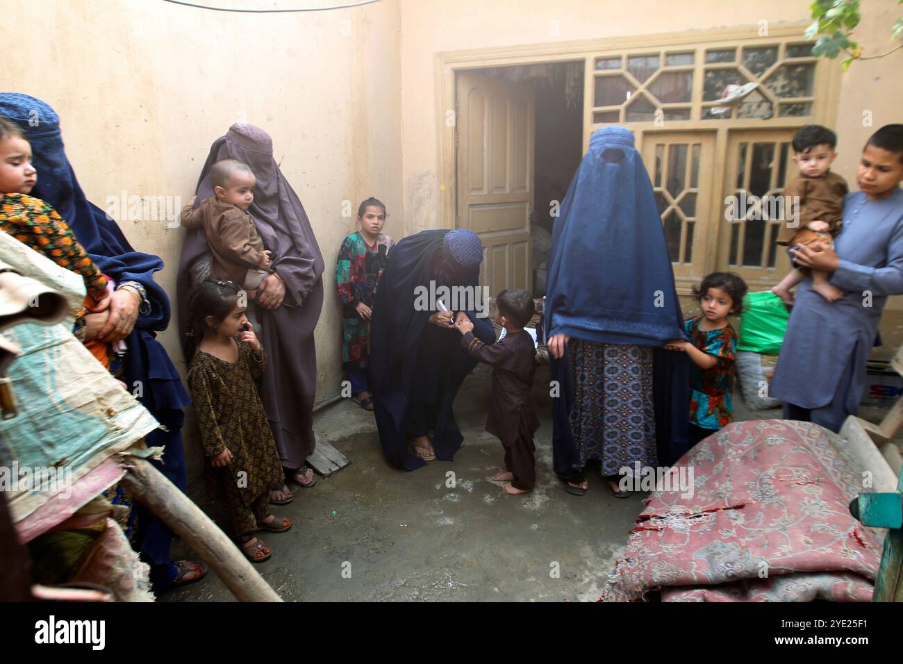 A health worker, center, marks the finger of a child after giving a ...