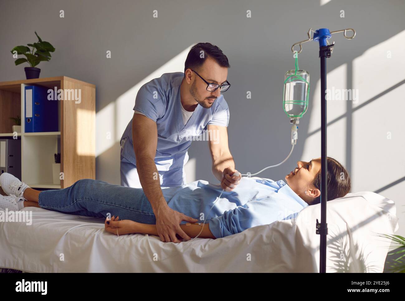 Doctor Administering IV Drip Therapy to Patient in Hospital Stock Photo ...