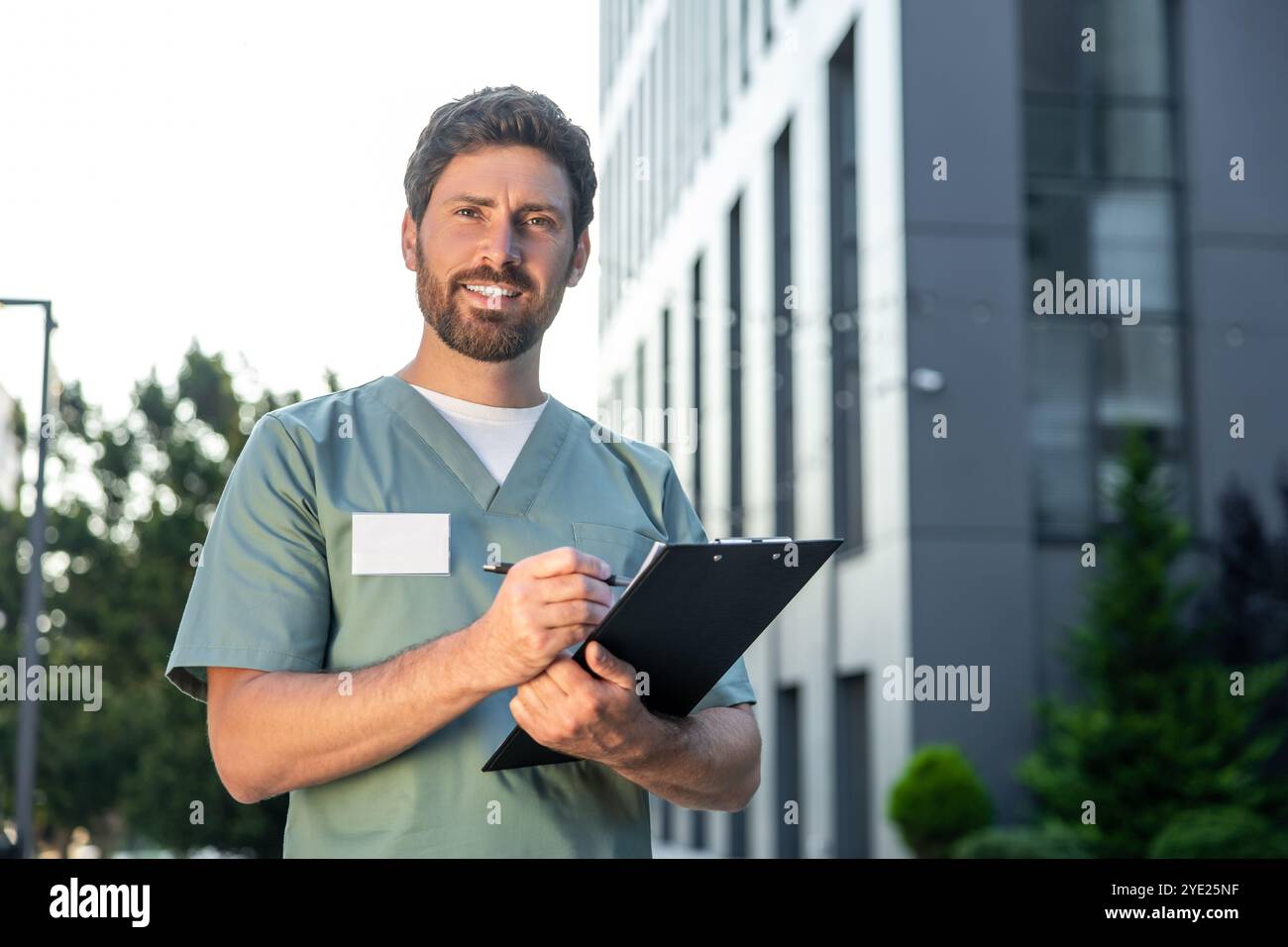 Man wearing medical uniform and stethoscope standing outside hospital ...