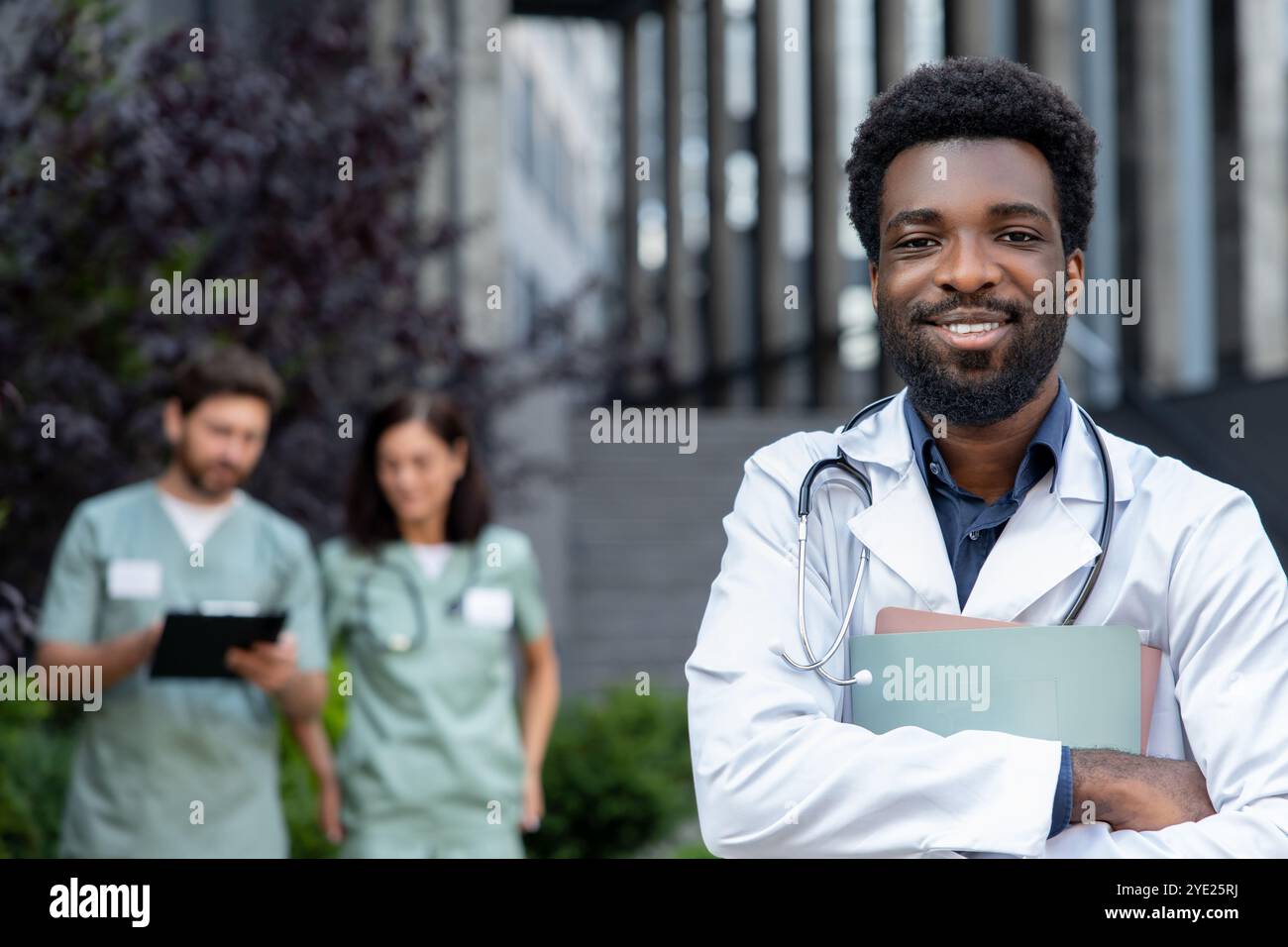 Man wearing medical uniform and stethoscope standing outside hospital ...