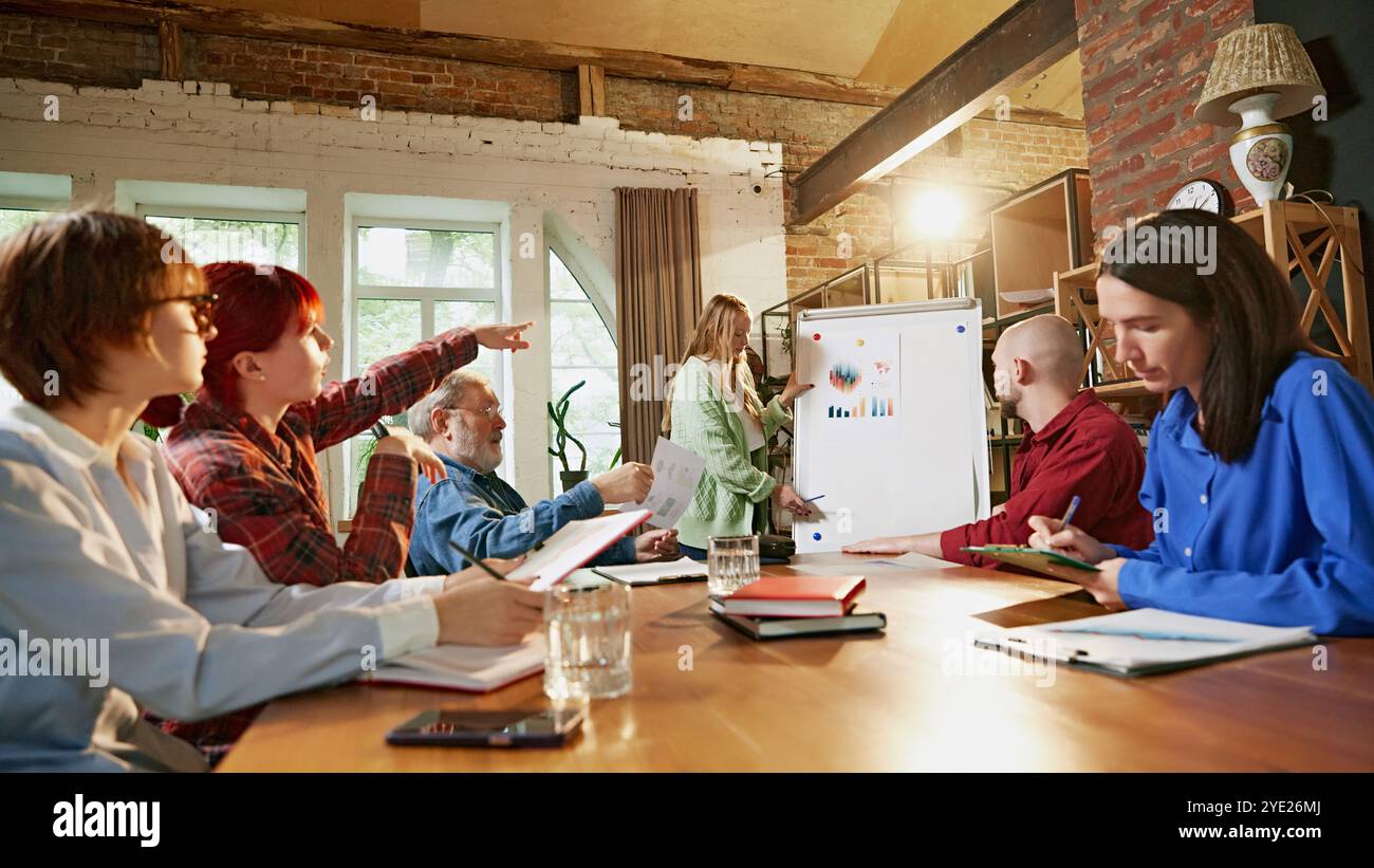 Multigenerational team collaborates on project, exchanging ideas in ...