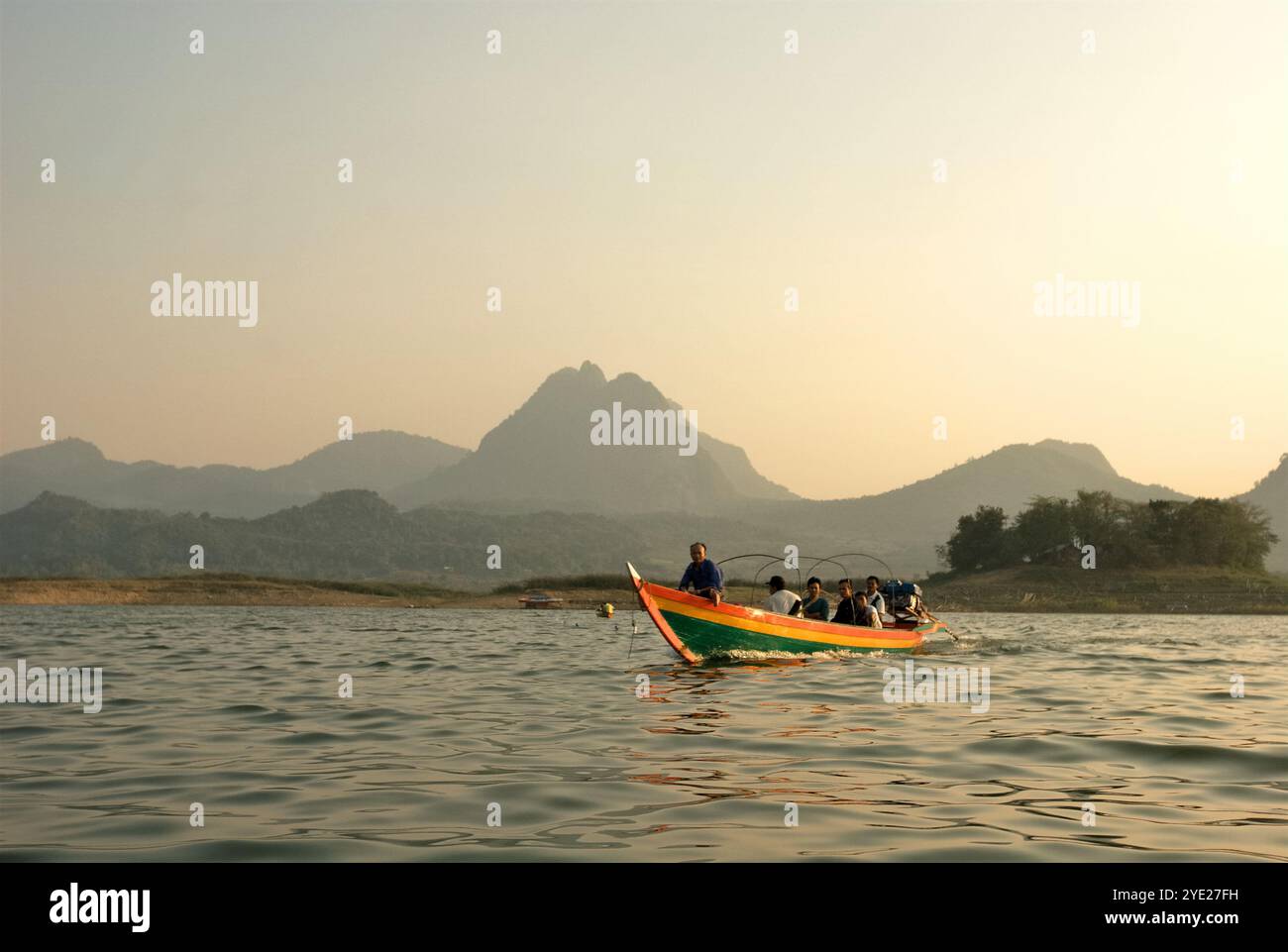A motorized boat transporting people across Jatiluhur dam in West Java ...