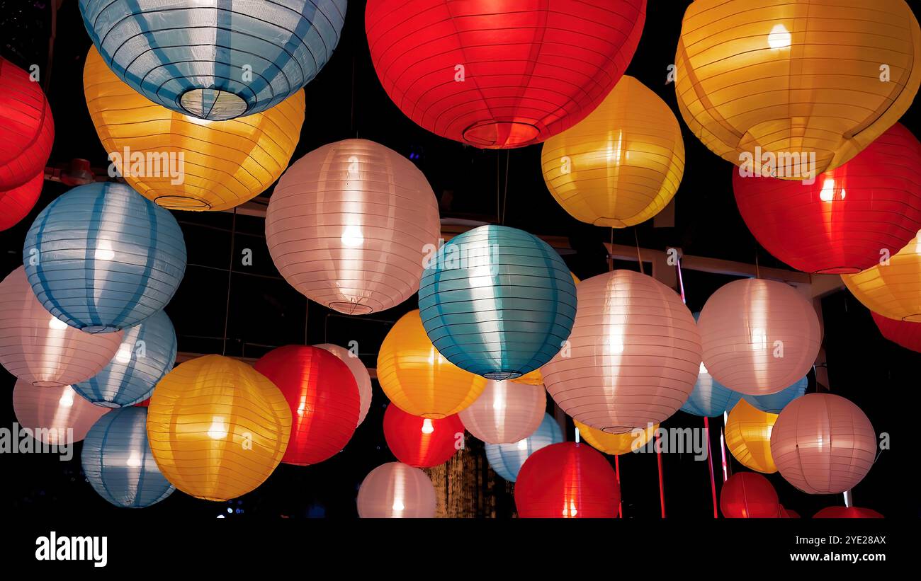 Colorful Various illuminated paper lanterns lights hanging in dark background at Thai Red Cross ...