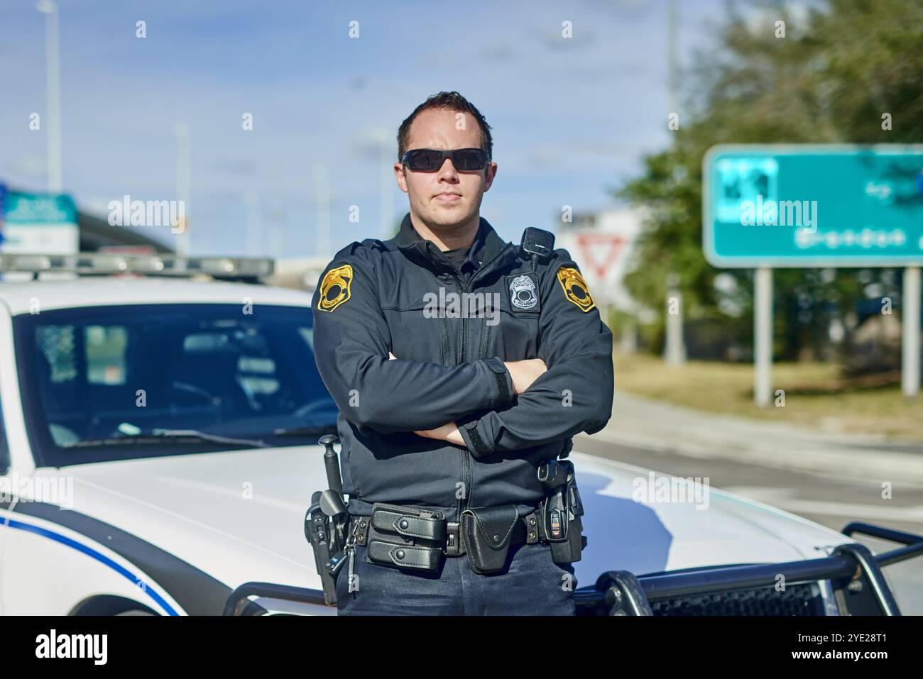 Man, arms crossed and police officer on duty, outdoor and uniform for ...