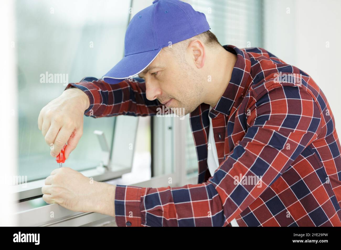 a worker is fixing a window Stock Photo - Alamy