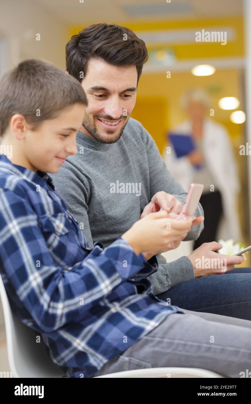 father and son waiting to visit pediatrician Stock Photo - Alamy