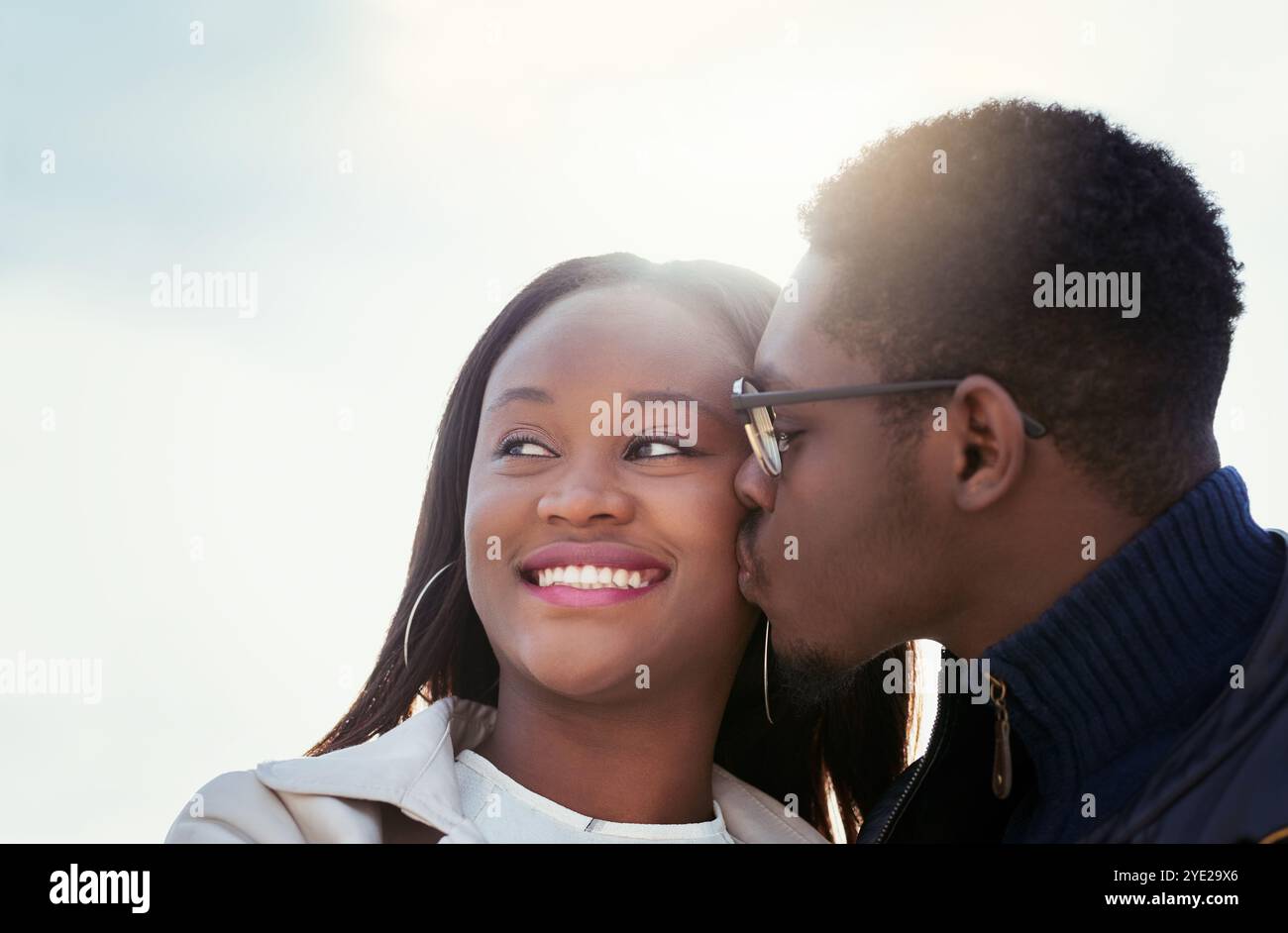 Kiss, happy and African couple in nature together for bonding, relationship and relaxing ...