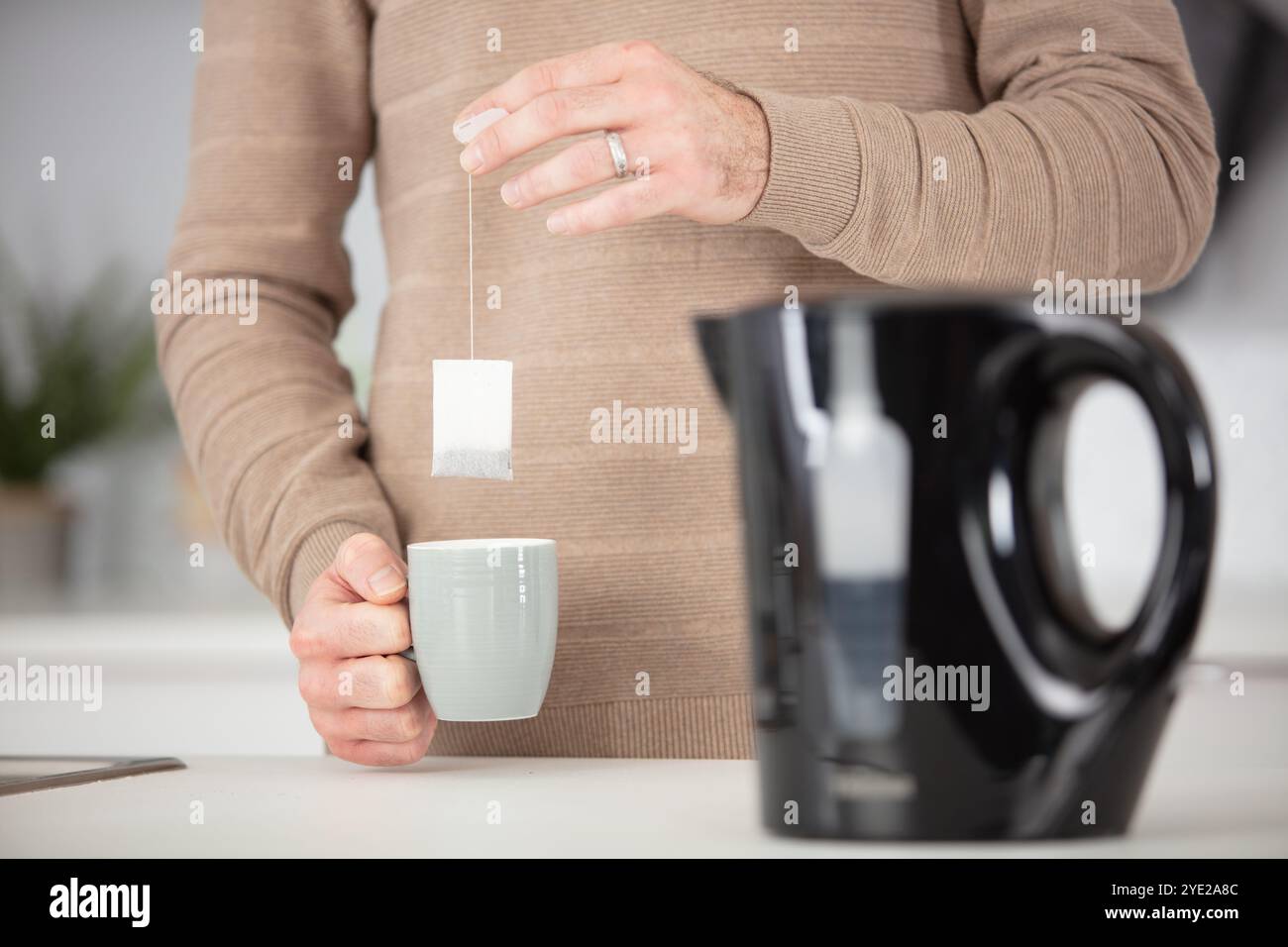 woman soaking tea bag in grey cup Stock Photo - Alamy