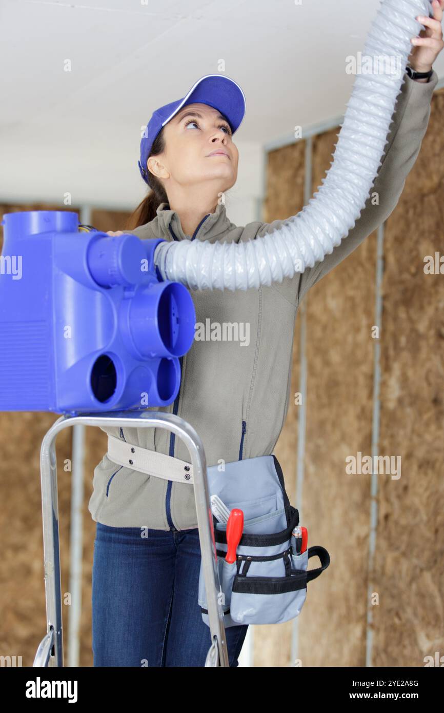 female engineer installing an air conditioning unit Stock Photo - Alamy