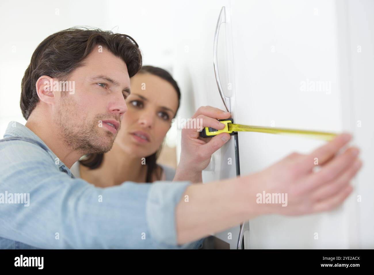 couple measuring a wall with tape meter Stock Photo - Alamy