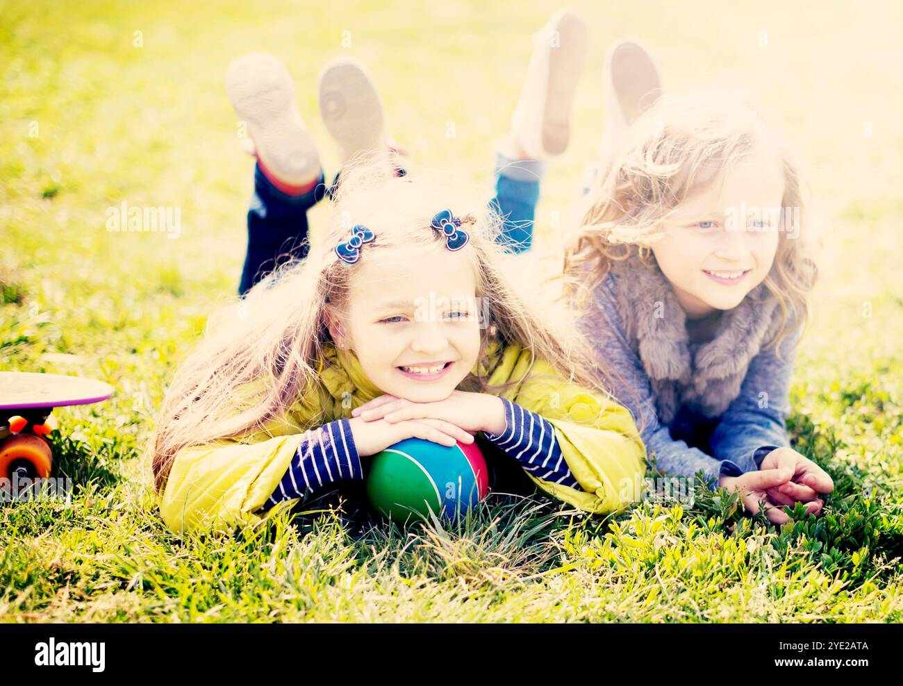 Two girls lie on grass Stock Photo - Alamy