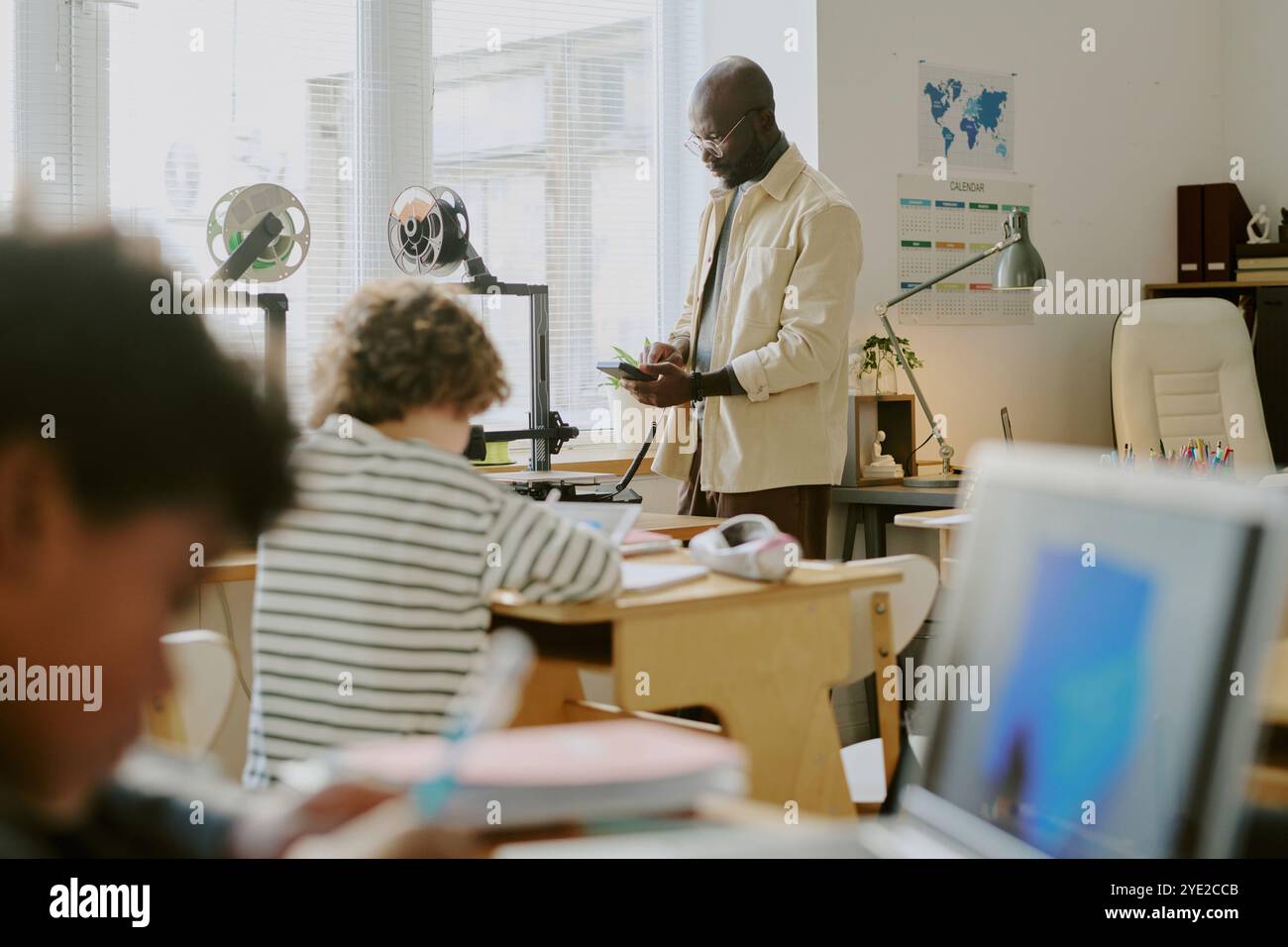 Teacher engaging with student in classroom environment, providing ...