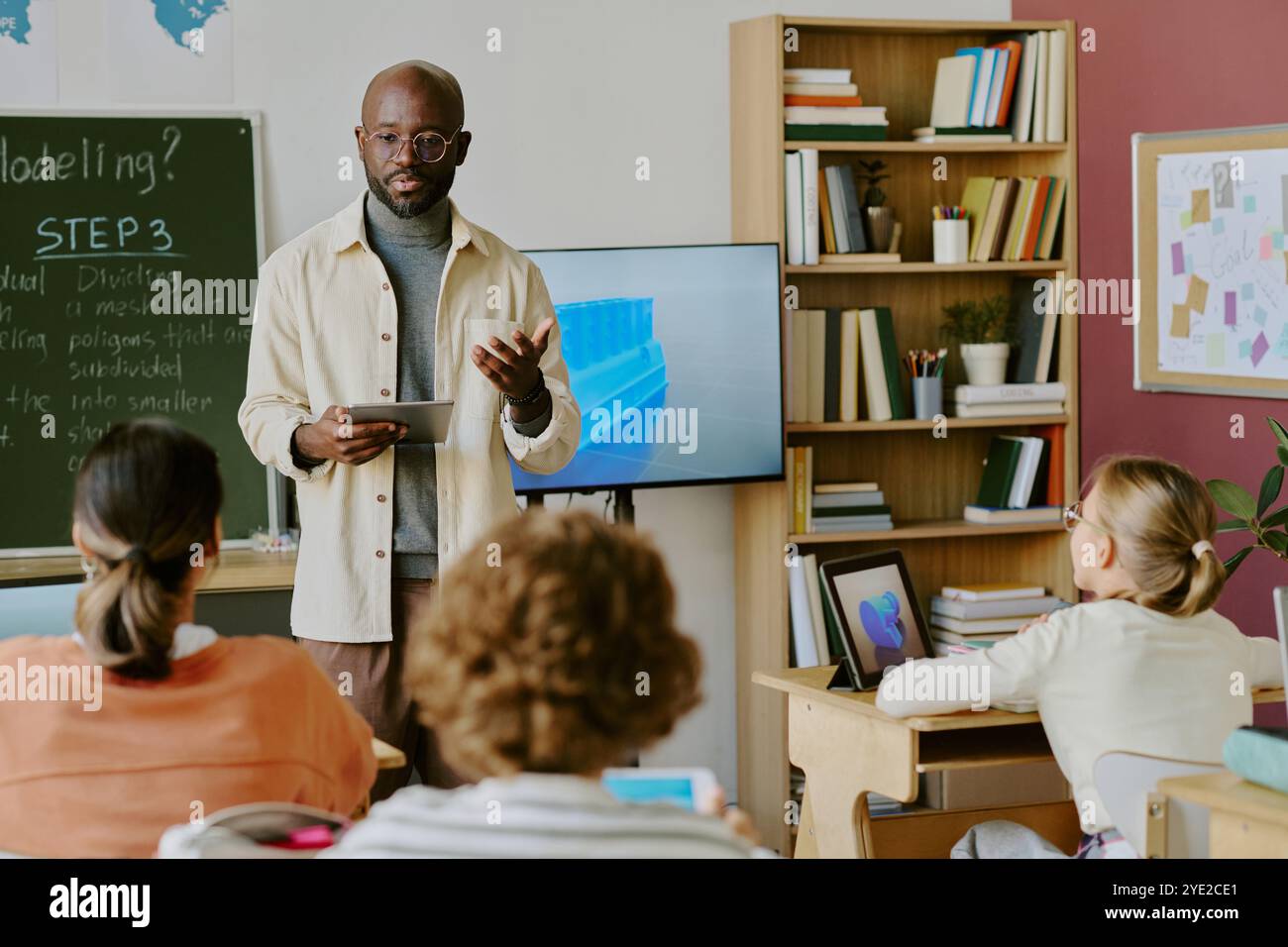 Experienced teacher using tablet leading group discussion in classroom ...