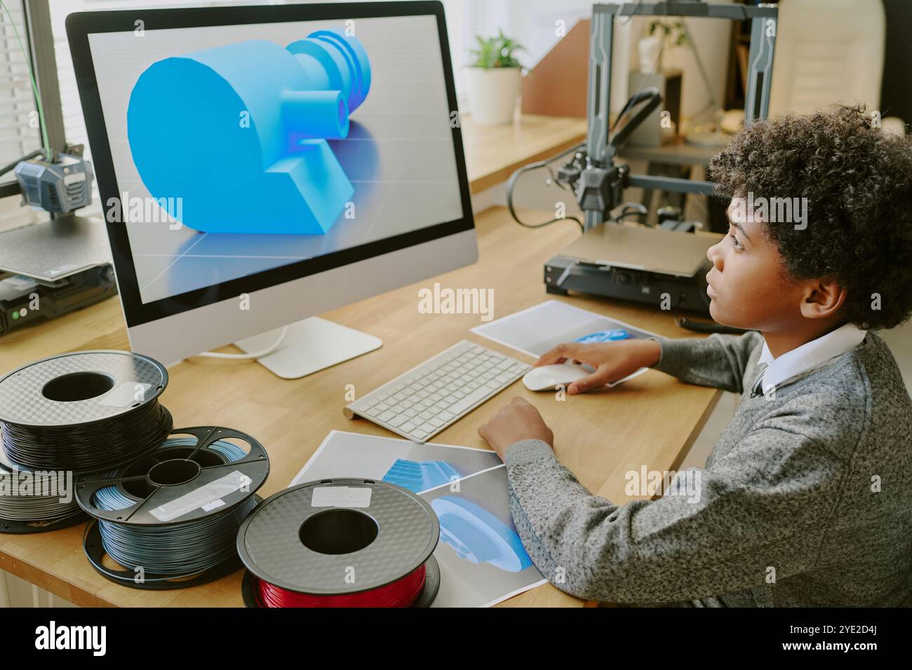 Young child engrossed in creating 3D models on computer while seated at ...