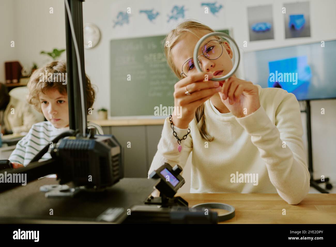 Two students engaging in hands-on learning with 3D printing technology ...