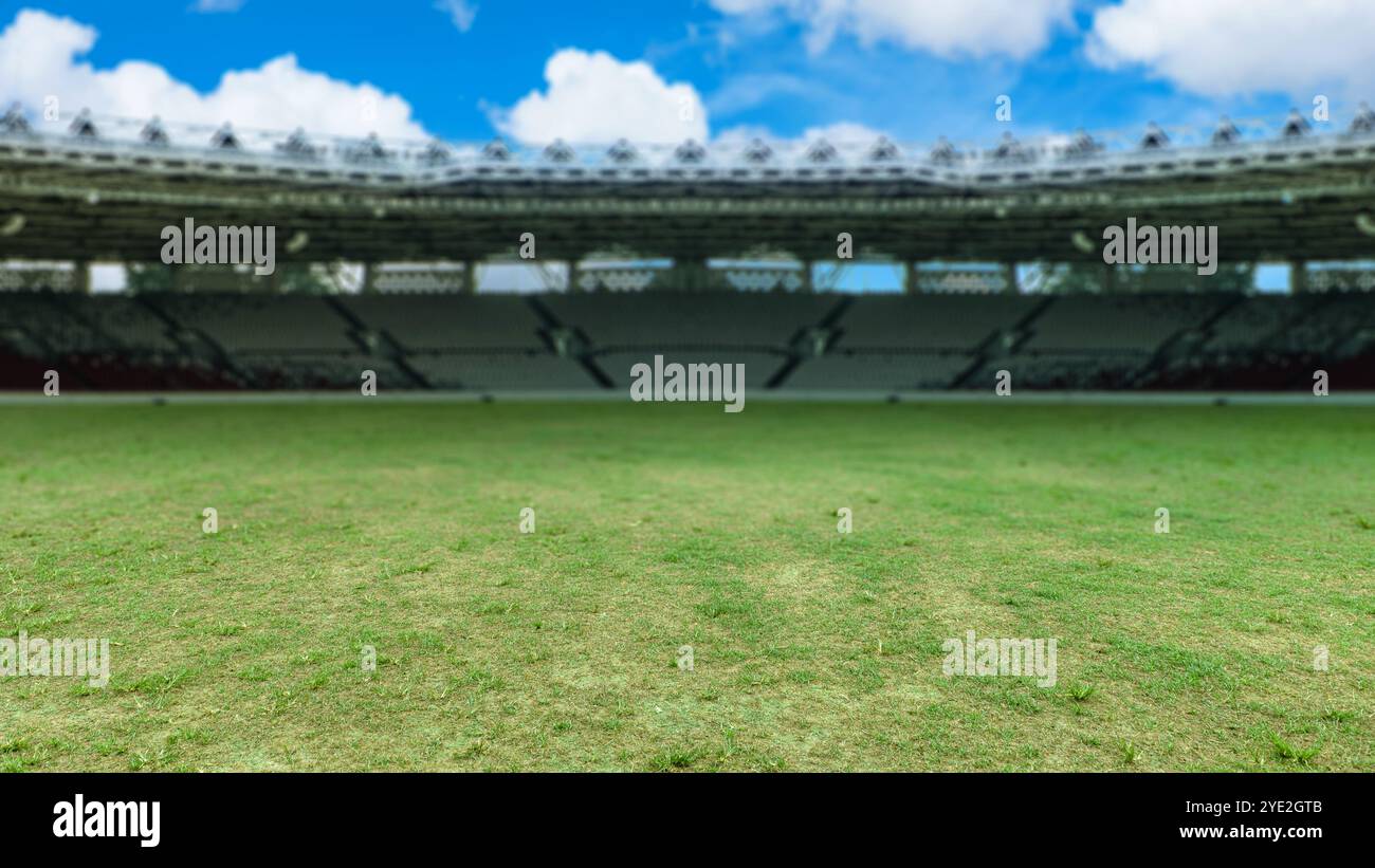 Empty football stadium with green field and blue sky. The field is ...