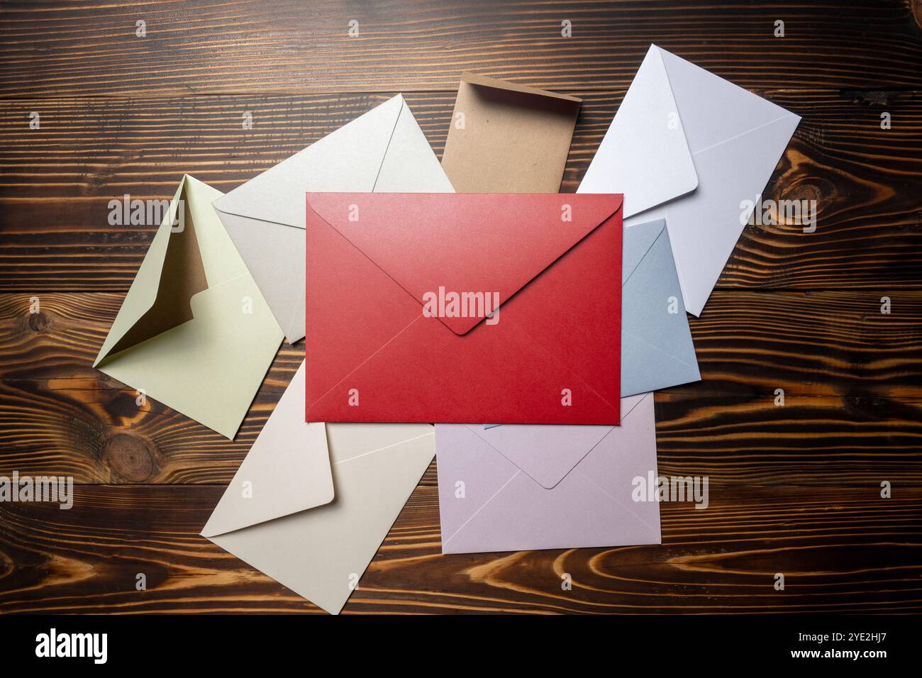 Top view of stack of envelope and postcard on wooden background. The ...