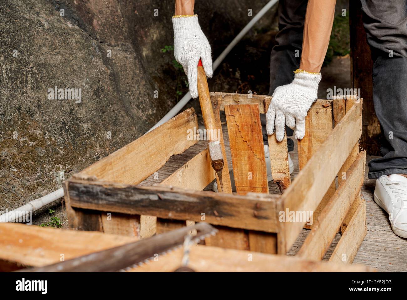 Workers in safety vest and glove using axe to work disassembling pallet ...