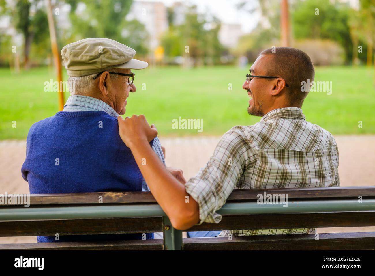 Portrait of happy grandfather and grandson in park. They are spending ...