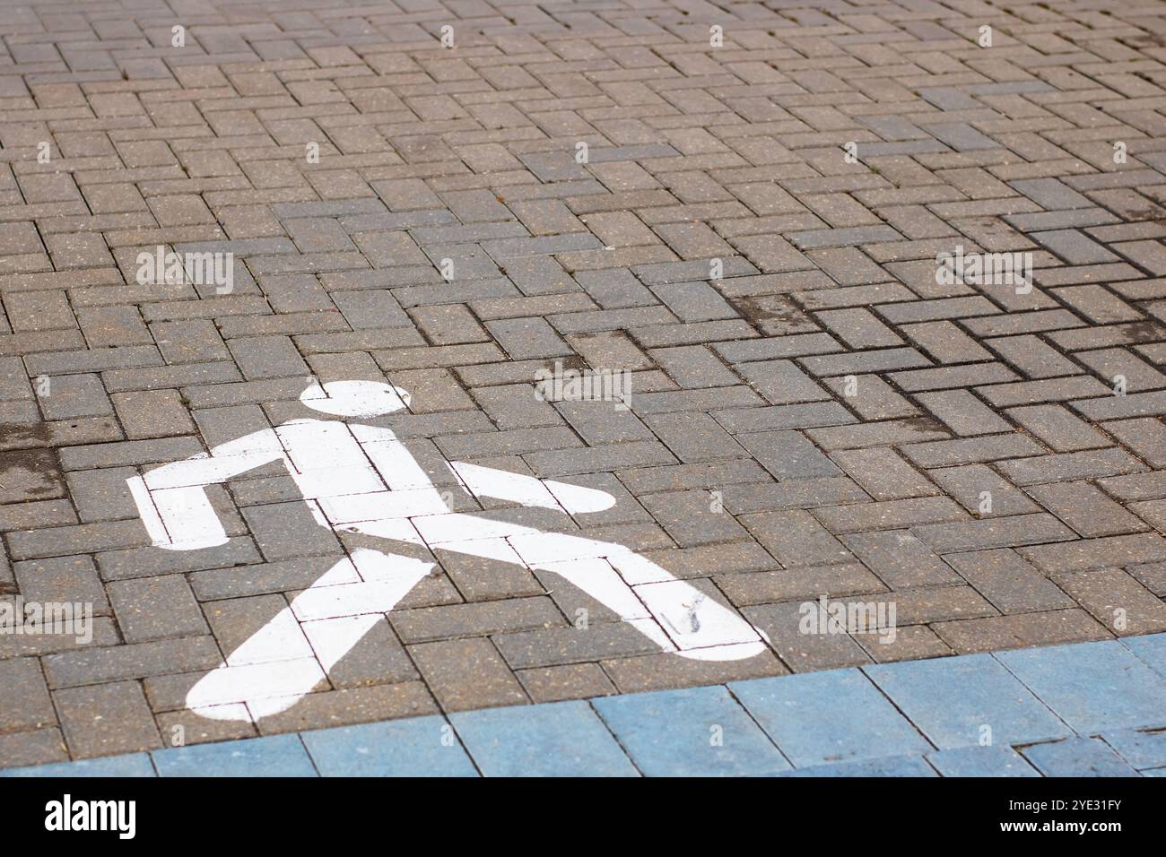 A bright white walk sign is clearly painted on a wellmaintained and ...