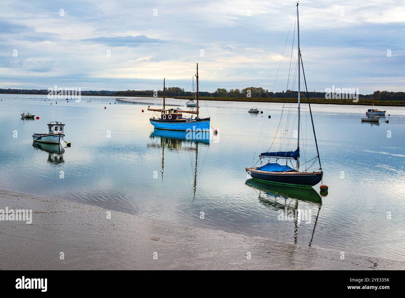 Moored boats at low tide on the River Deben near Bawdsey Quay ...