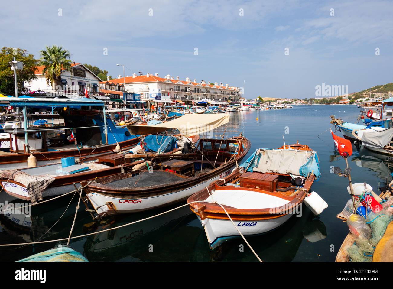 Traditional Turkish fishing boats moored alongside the harbour in Foca ...