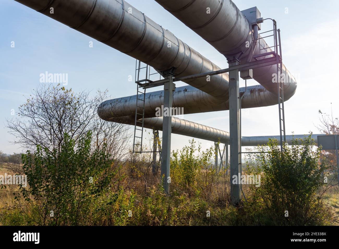 Industrial metal pipeline structure stretching over rural landscape ...