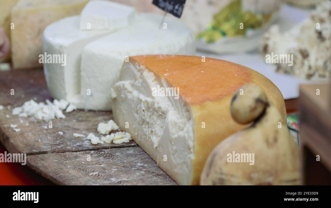 A variety of artisan cheeses is showcased at a market in Alba, Italy ...