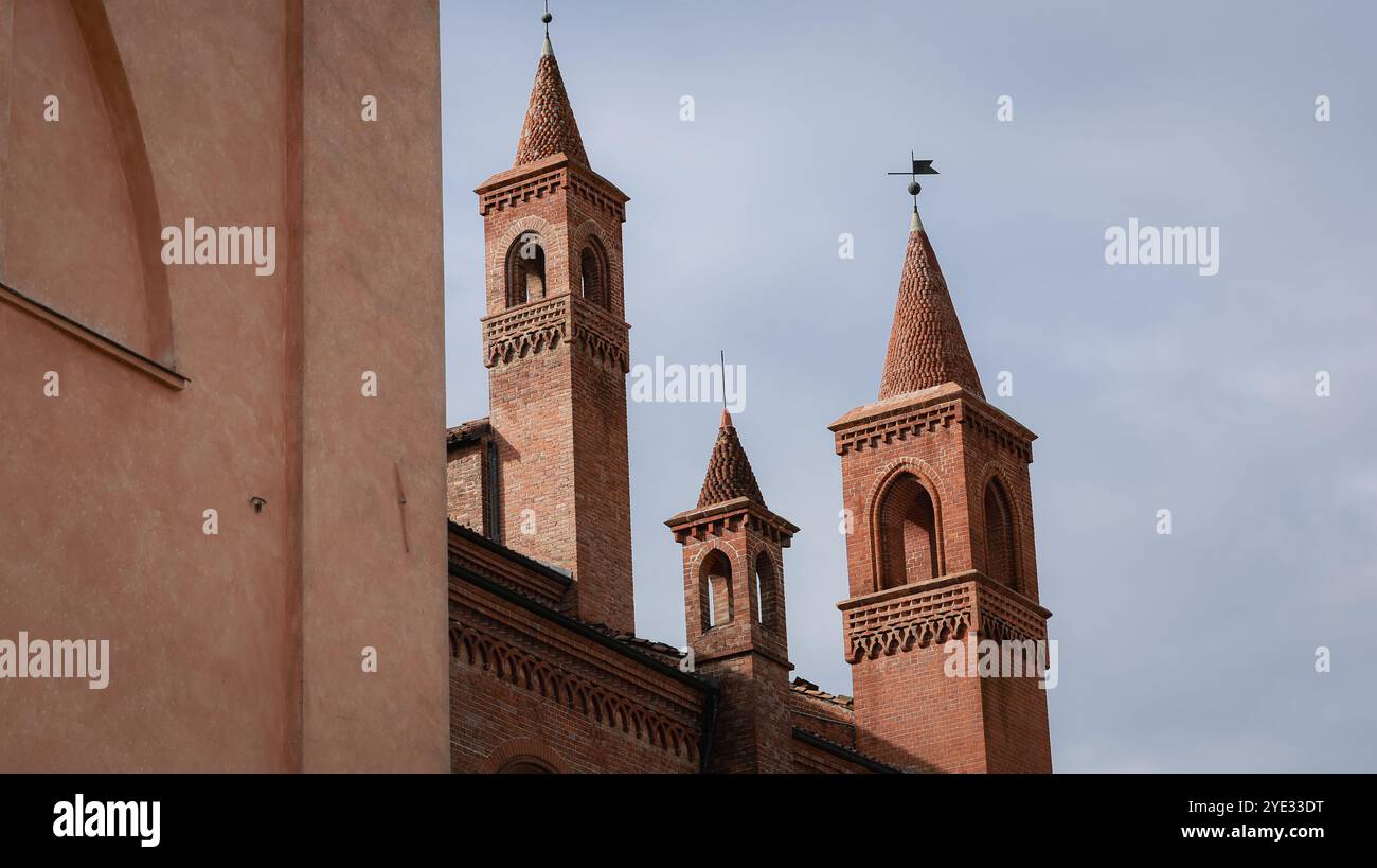 The beautiful towers of an old building in Alba, Italy, stand against a ...