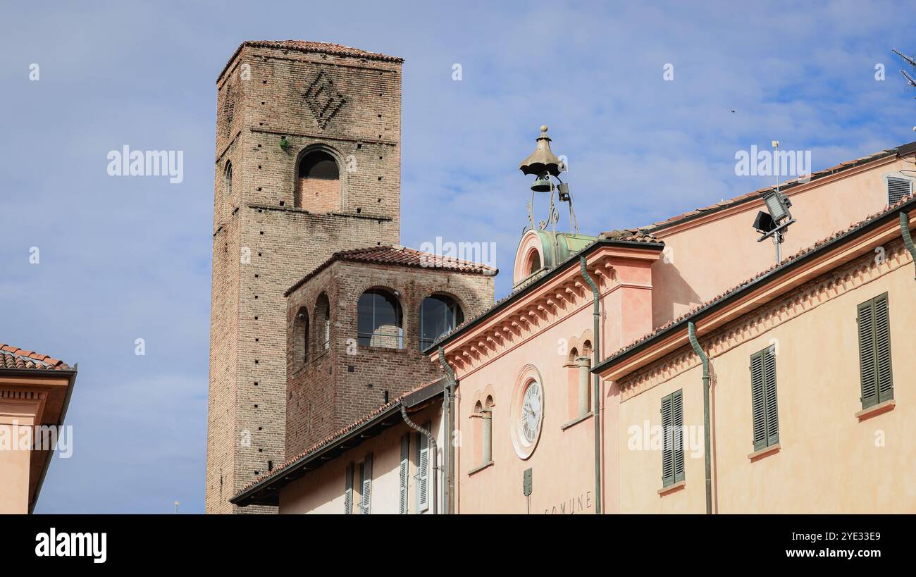 A charming view of old buildings in Alba, Italy featuring a tall clock ...