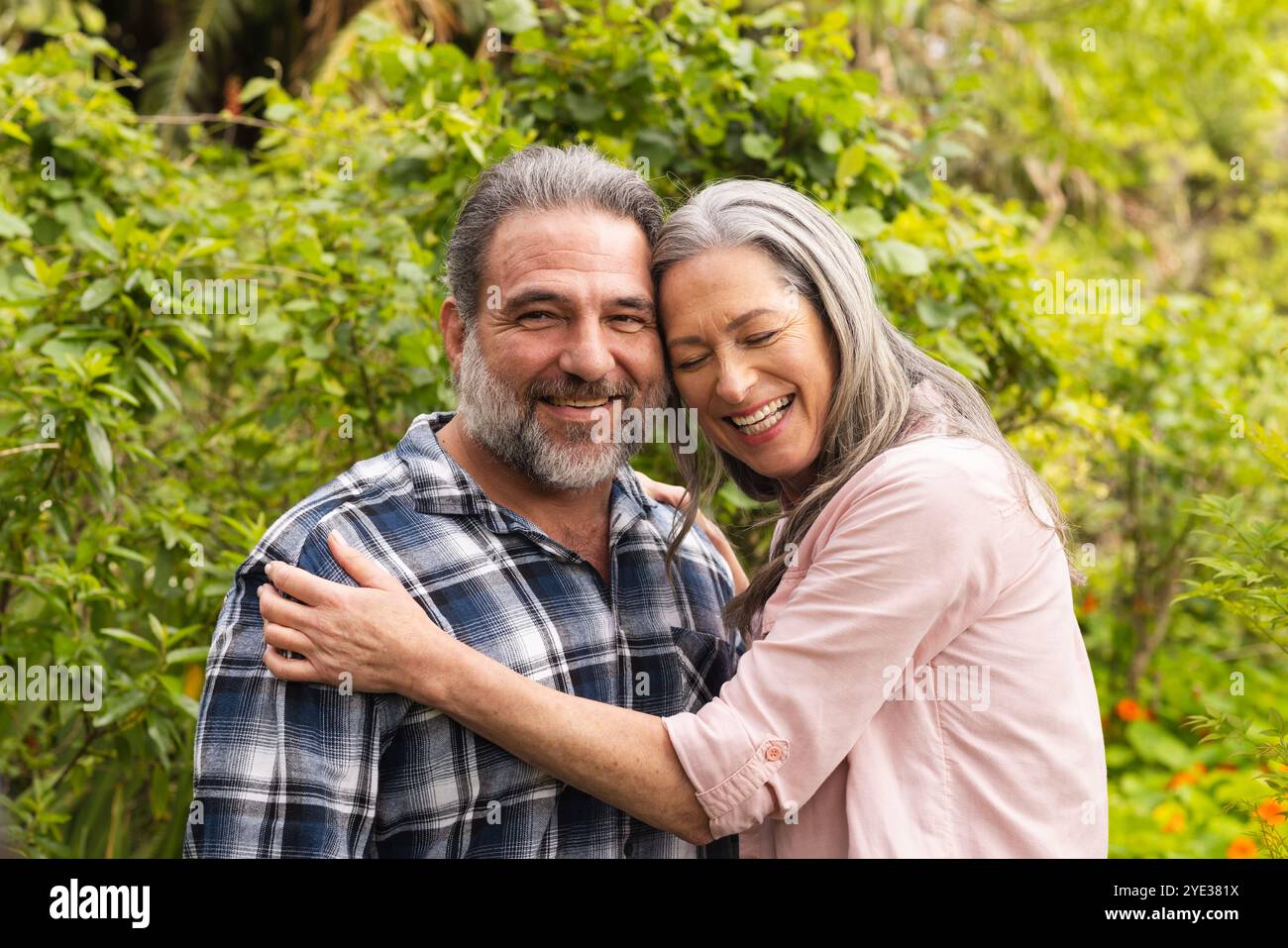 Happy mature couple embracing outdoors, enjoying nature and smiling ...
