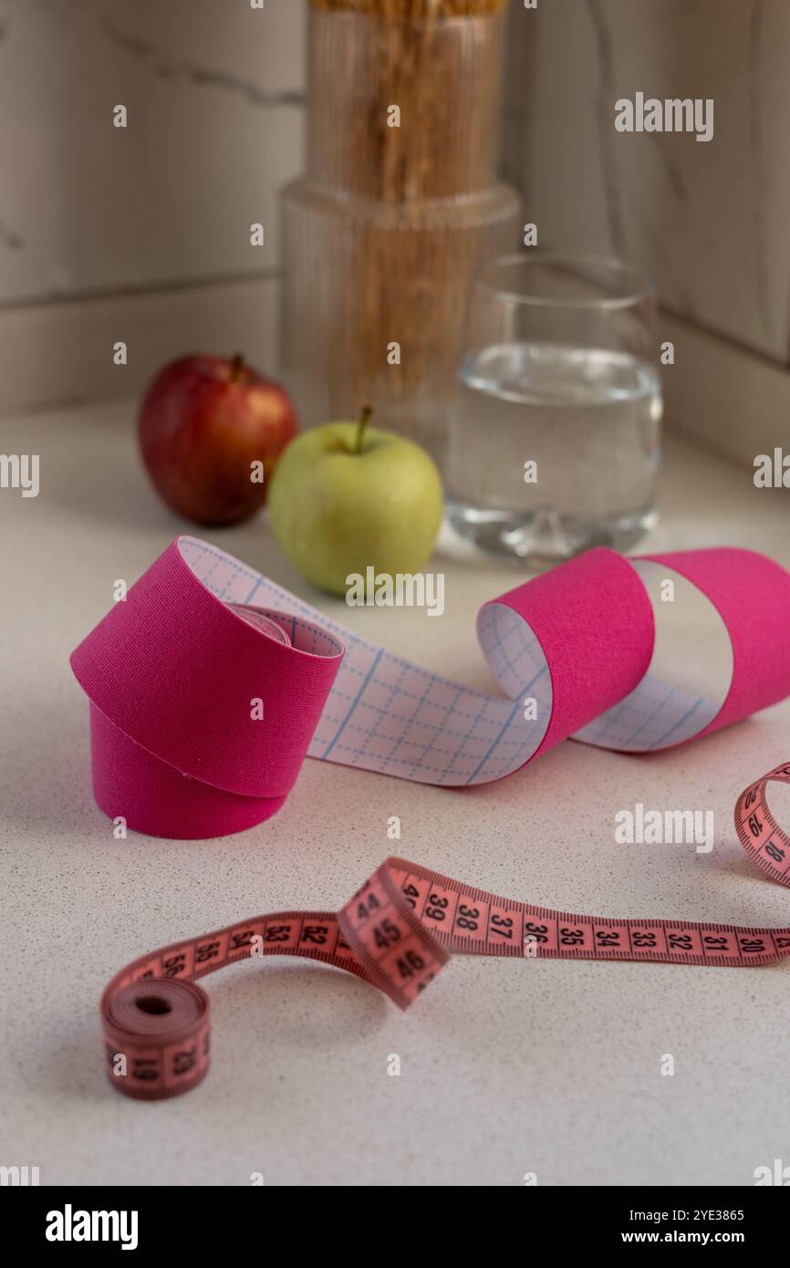 Pink kinesio tape with a measuring tape lying on a white background ...