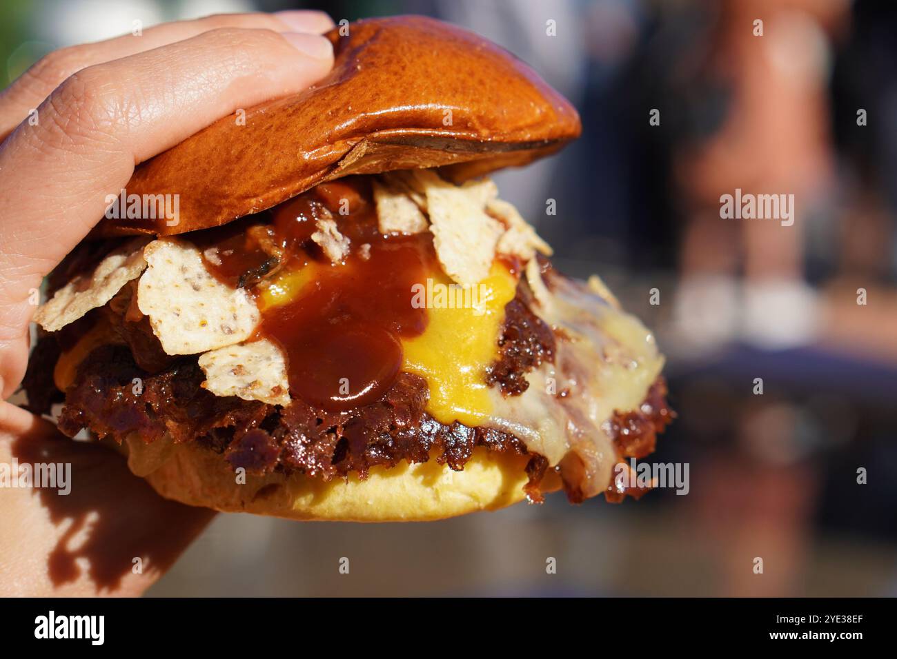 street food. hand holding a delicious smash burger Stock Photo - Alamy