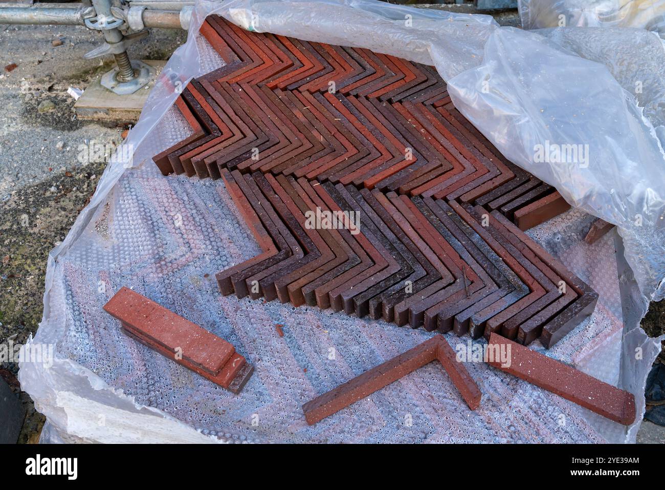 A collection of red corner bricks is neatly arranged in a zigzag ...