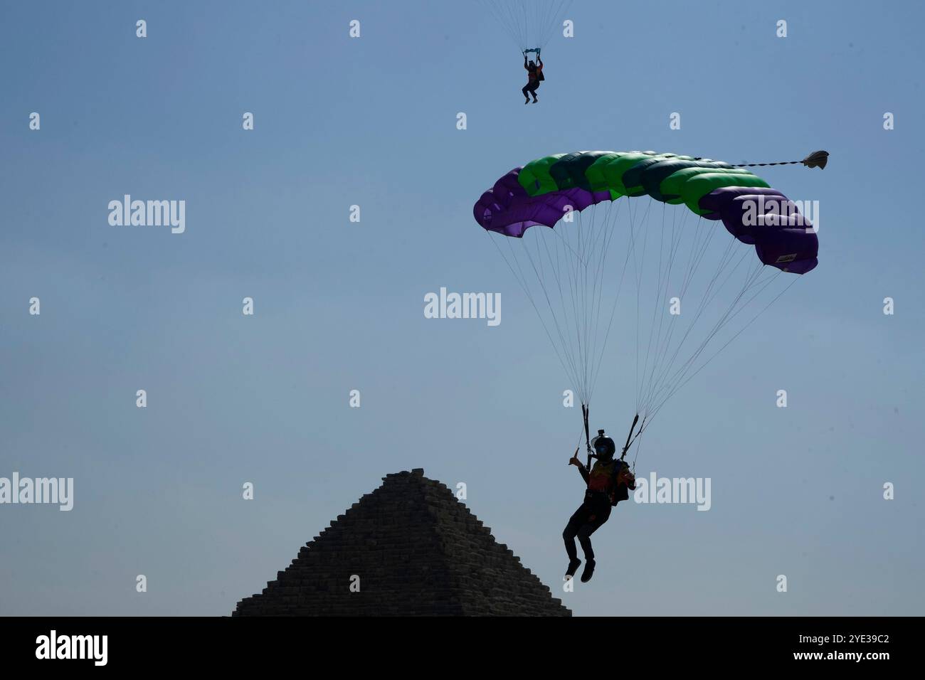 Skydivers parachute at the historical site of Giza Pyramids, on the ...