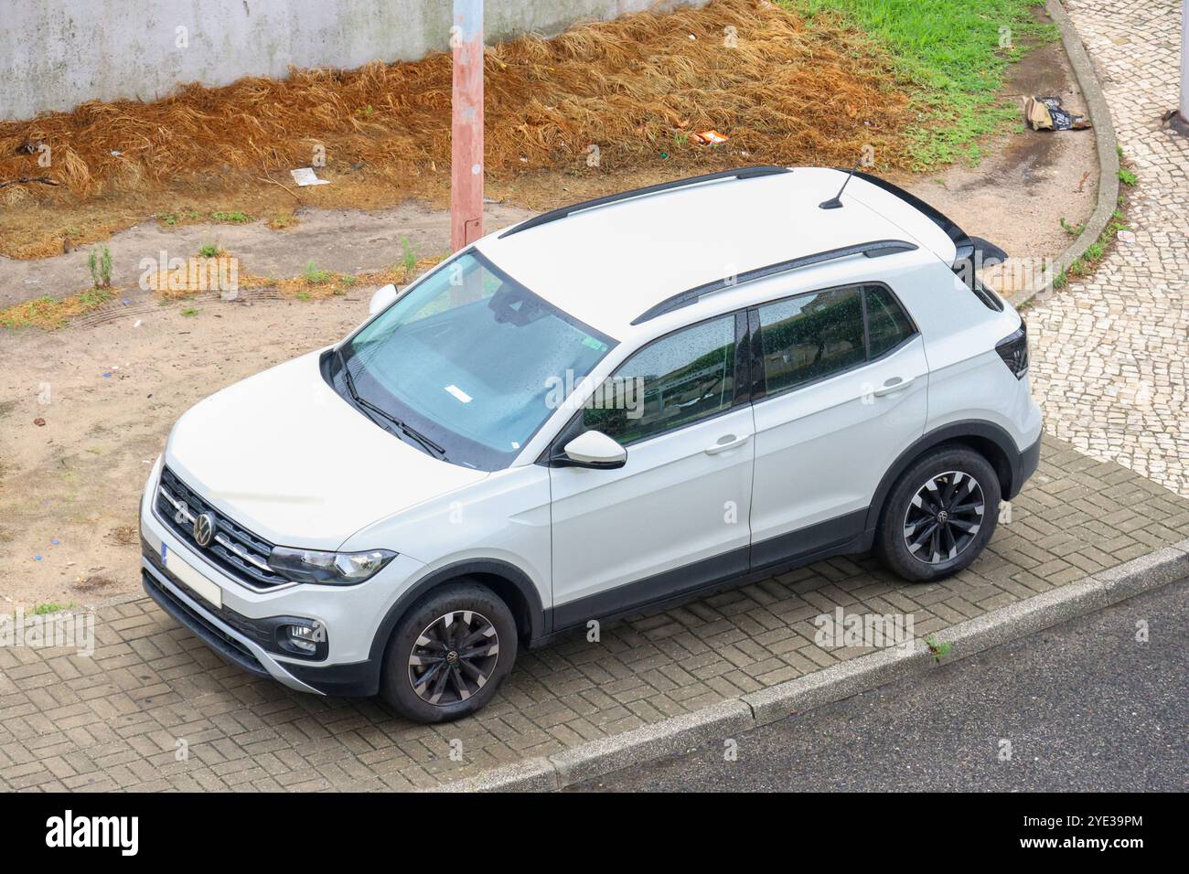 Modern white suv crossover car parked on a cobblestone sidewalk in an ...