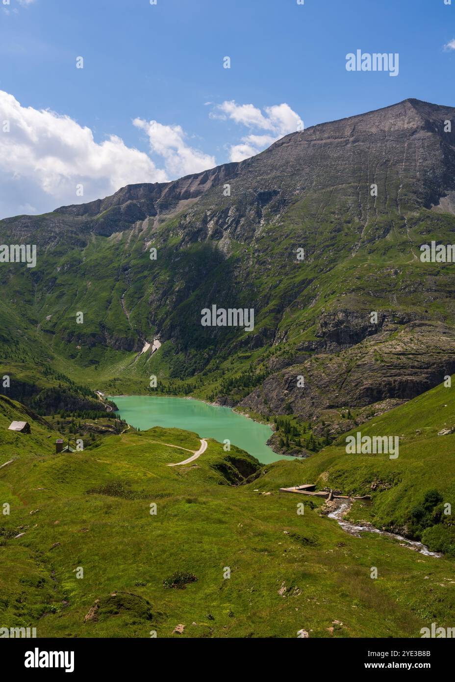 Small blue lake between mountain slopes. Small hotel in mountain, hut ...