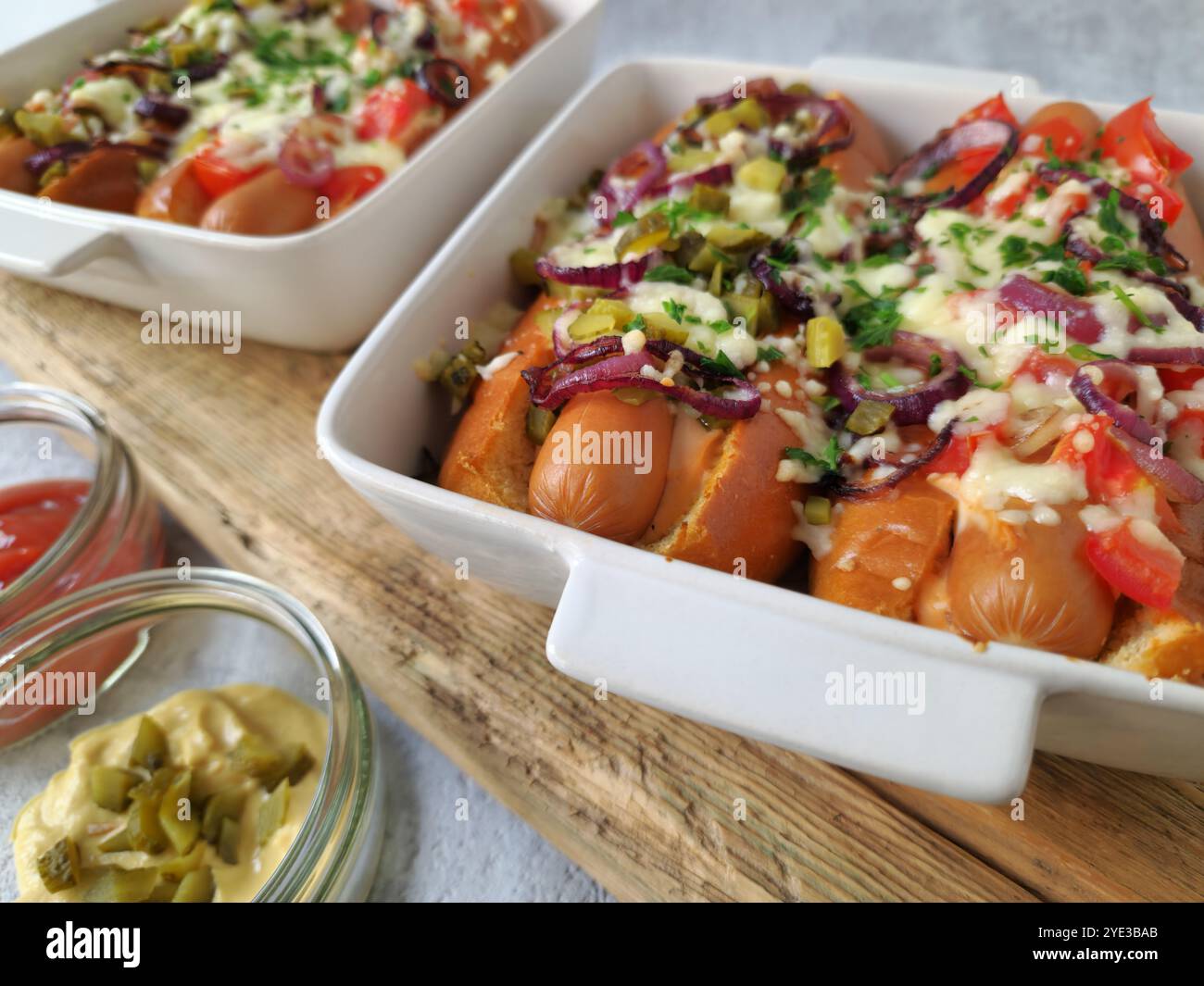 Baked Hot Dogs with Melted Cheese, Red Onions, Tomatoes, and Pickles in ...
