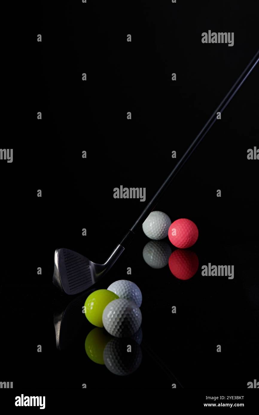 golf club and golf ball photographed against a dark background with ...
