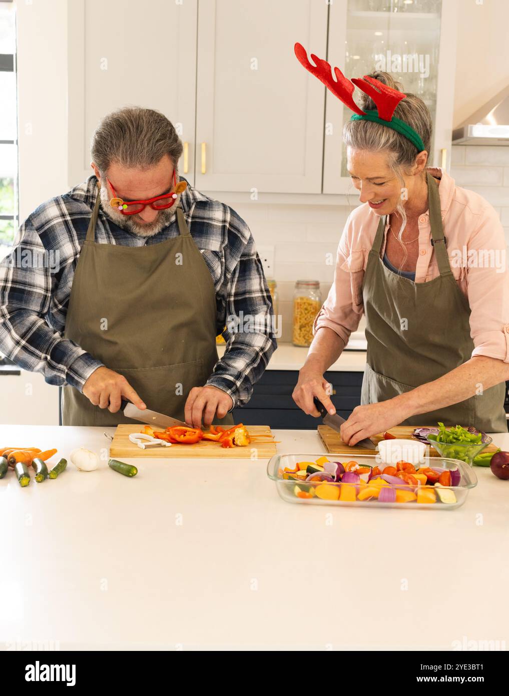 Christmas time, mature couple preparing vegetables in kitchen, at home ...