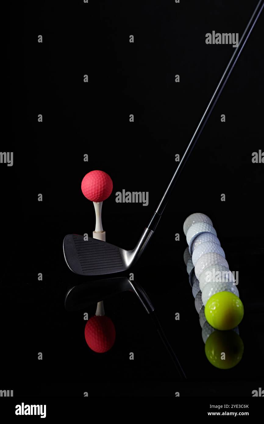 golf club and golf ball photographed against a dark background with ...