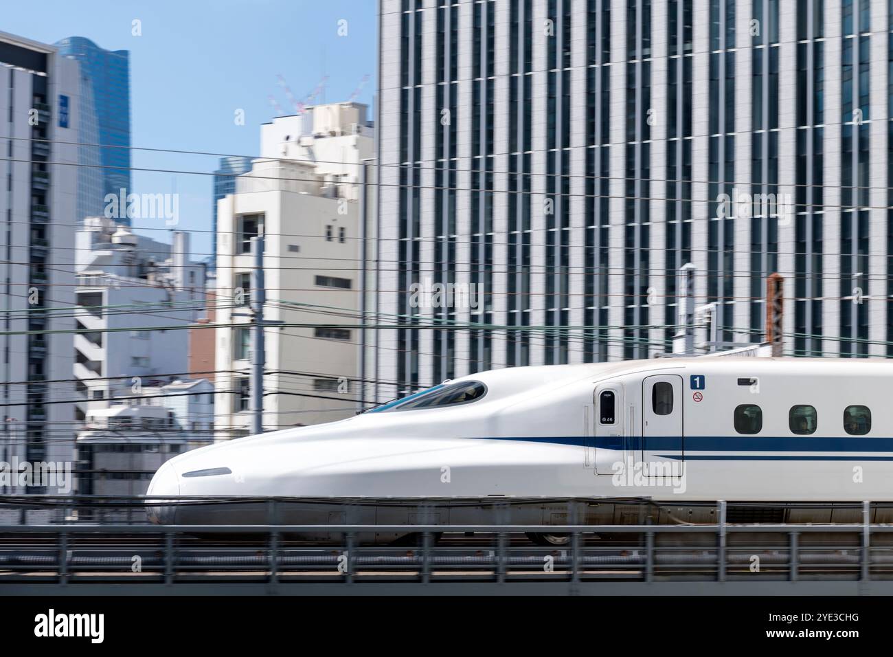 Bullet train passing between buildings in Tokyo, Japan Stock Photo - Alamy