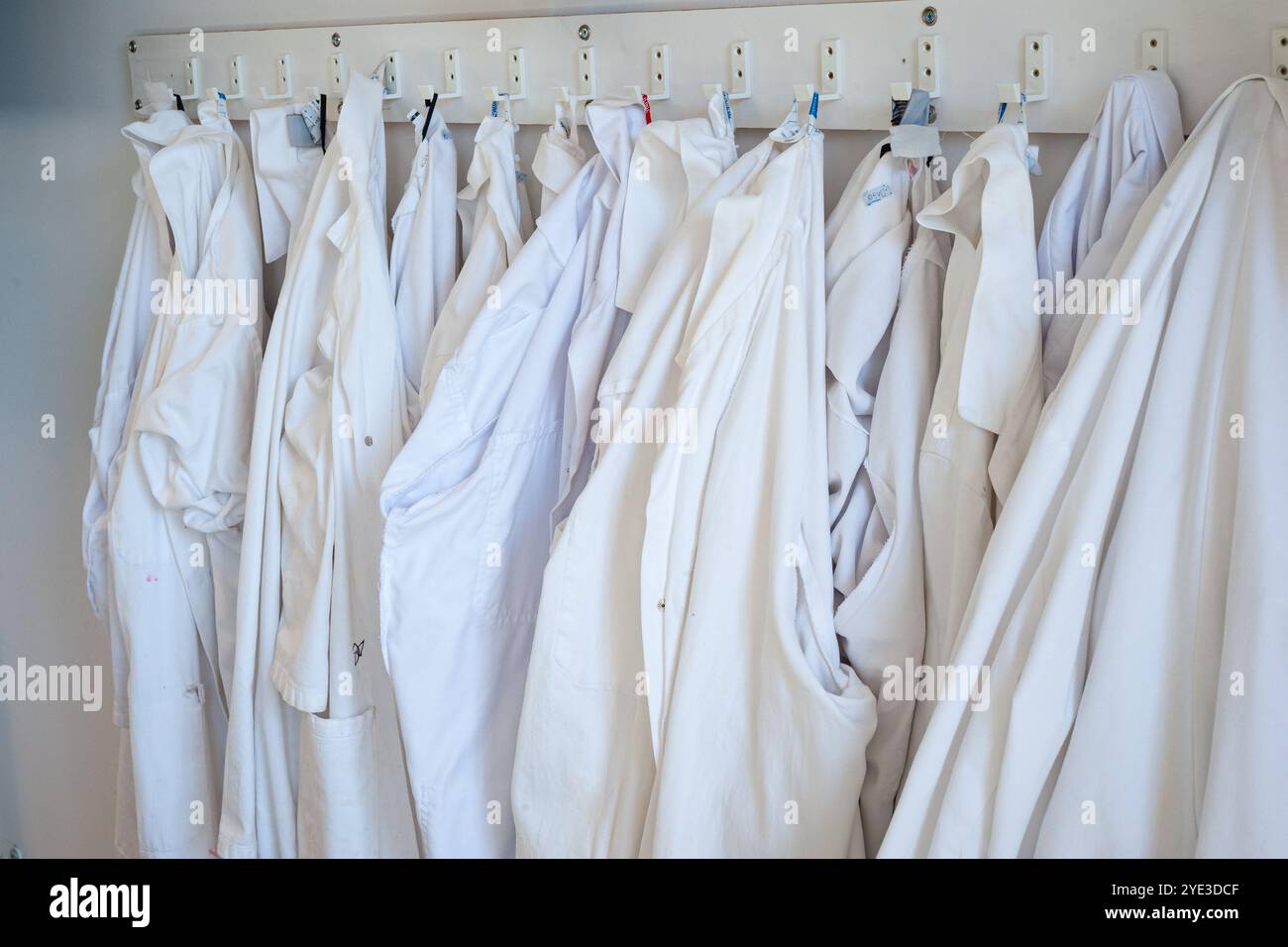 Row of lab coats for laboratory research in a practical classroom at a ...