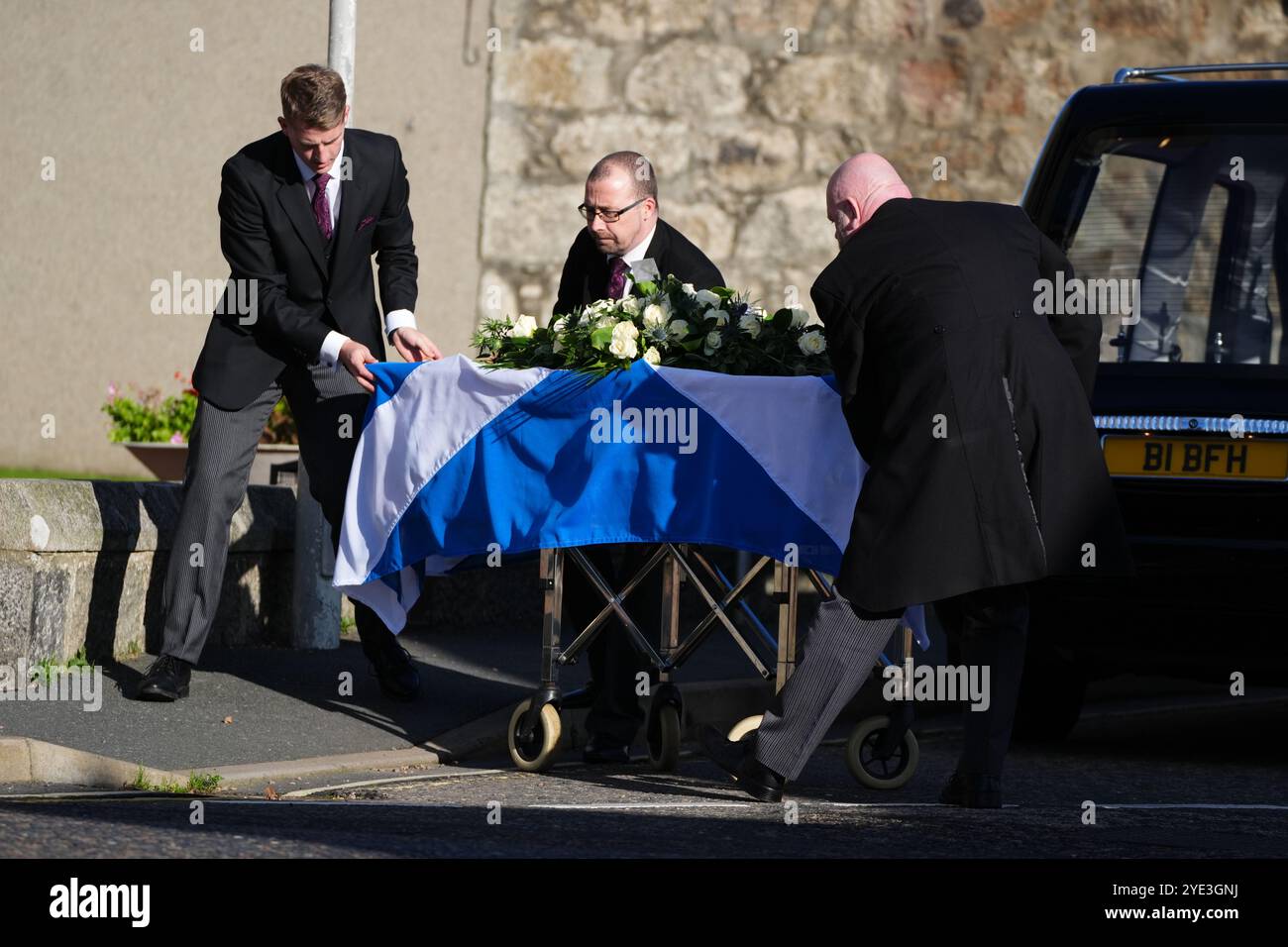 Pall bearers with the coffin, draped in a Saltire flag, arrive for the ...